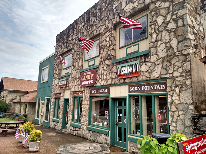 The stone facade of Hardy Sweet Shop stands like a sugar-dusted fortress, those cheery red awnings practically shouting "abandon diets, all ye who enter here!"