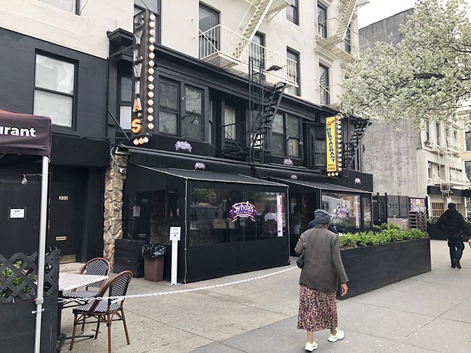 The classic New York storefront beckons with its iconic yellow sign &ndash; Sylvia's standing proud on Malcolm X Boulevard like a culinary lighthouse in Harlem.