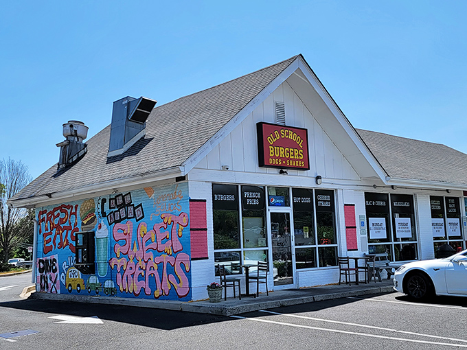 Old School Burgers glows like a beacon at twilight, its colorful mural promising flavor adventures within. The perfect neighborhood joint where memories are made. 