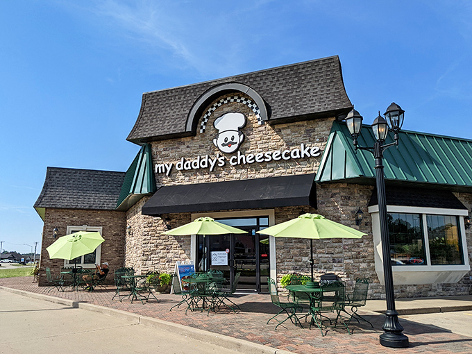The charming stone facade of My Daddy's Cheesecake welcomes visitors with cheerful green umbrellas and outdoor seating - an irresistible invitation to dessert paradise.