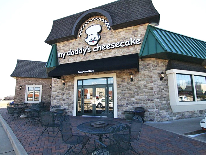 The charming stone facade of My Daddy's Cheesecake welcomes visitors with cheerful green umbrellas and outdoor seating - an irresistible invitation to dessert paradise. 