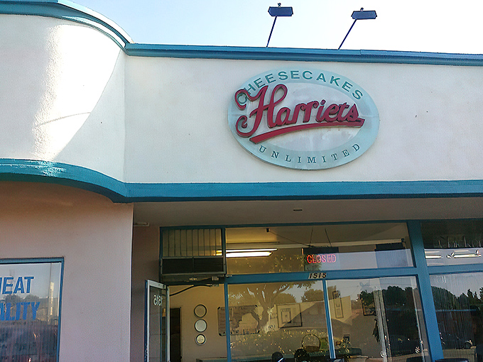 The unassuming storefront of Harriet's Cheesecakes Unlimited in Inglewood &ndash; proof that culinary greatness often hides in plain sight behind modest blue trim.