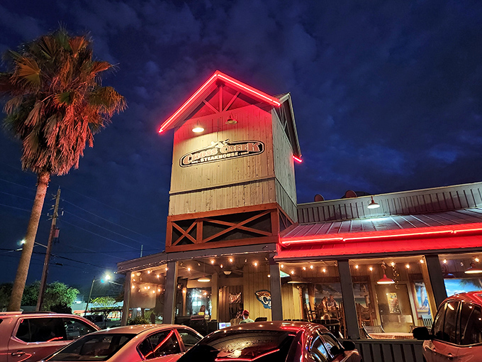 Cross Creek's neon-lit exterior transforms into a beacon of Southern comfort as dusk falls, promising culinary adventures within those wooden walls.