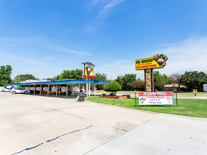 The classic drive-in canopy stands like a time portal to 1956, promising comfort food treasures beneath its nostalgic blue trim. 