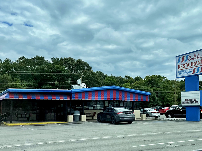 
The red and blue striped awning of Bulldog Restaurant stands like a culinary lighthouse on Highway 167, beckoning hungry travelers with its no-nonsense charm.