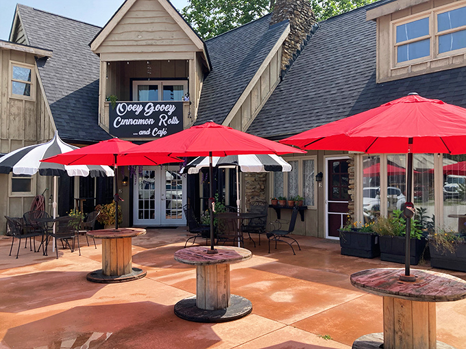 The charming cottage-style exterior of OoeyGooey beckons with bright red umbrellas and rustic wooden tables, promising sweet treasures within.