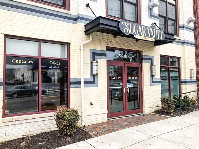The unassuming storefront of Sugar Vault beckons like a secret treasure map to dessert paradise. Yellow brick, red doors, and sweet promises await.