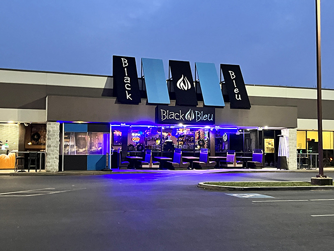 The blue glow of Black n Bleu's facade beckons hungry travelers like a culinary lighthouse in Mechanicsburg's evening landscape.