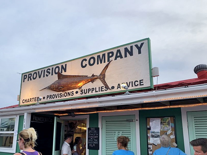 The unassuming entrance to seafood paradise &ndash; where that weathered fish sign promises more flavor than any fancy neon ever could.