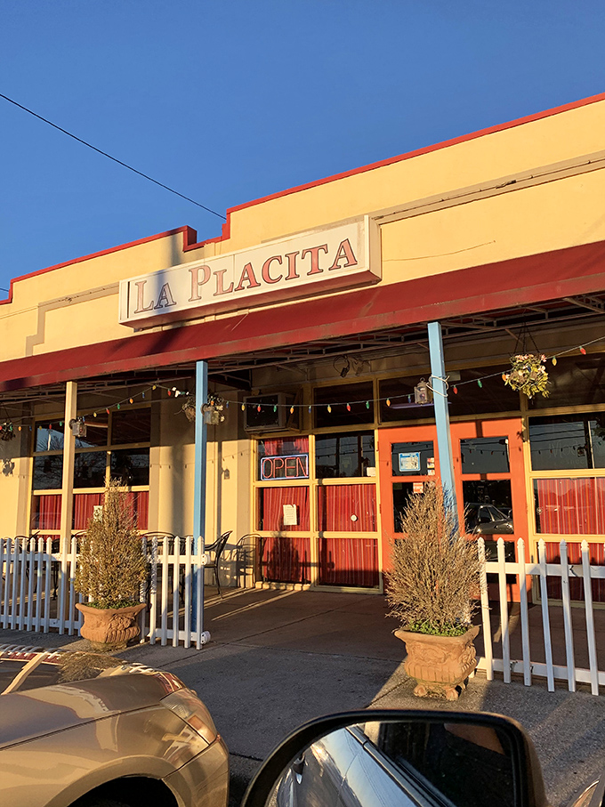 La Placita's cheerful exterior beckons with its bright yellow walls and red awning&mdash;like a sunset wrapped around a building that promises culinary adventure inside.