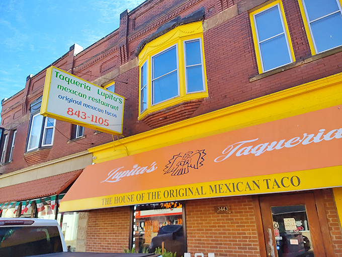 The bright orange awning of Taqueria Lupitas stands out like a beacon of culinary hope on this Detroit street corner, promising authentic Mexican flavors within.