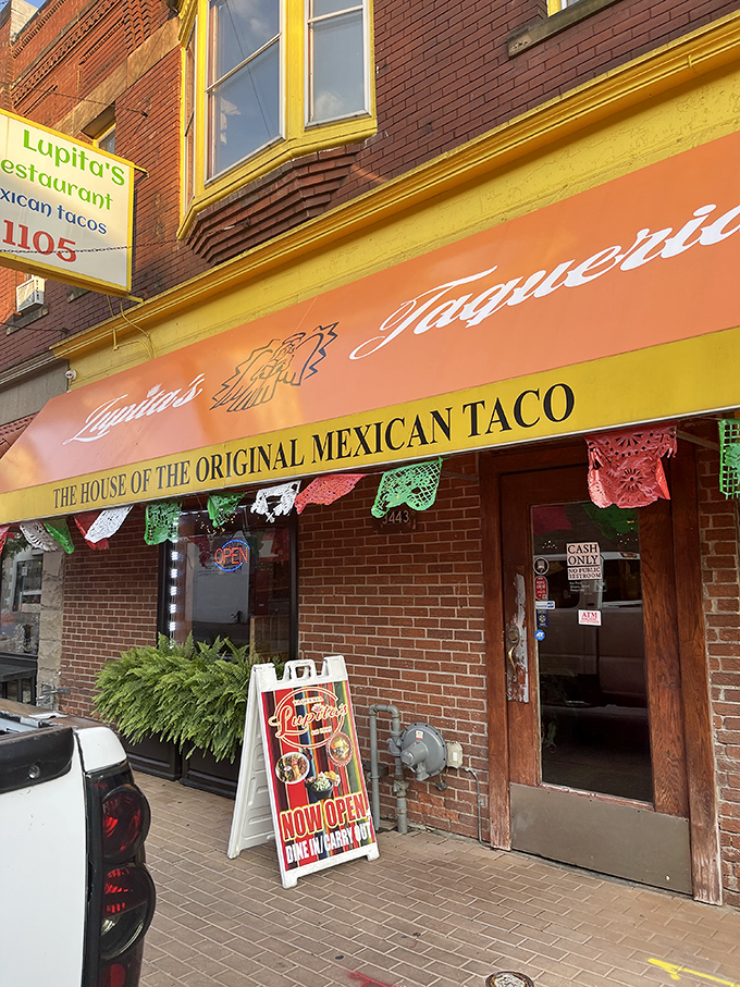 The bright orange awning of Taqueria Lupitas stands out like a beacon of culinary hope on this Detroit street corner, promising authentic Mexican flavors within.