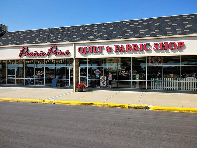The quilter's equivalent of Willy Wonka's factory beckons with its bright red signage, promising fabric treasures behind those unassuming storefront windows.