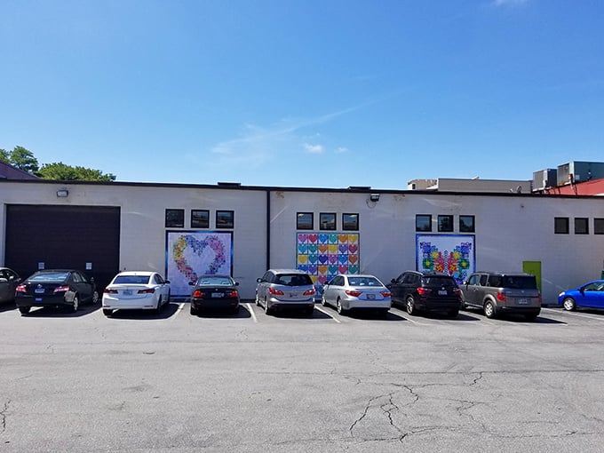 The unassuming exterior hides a crafter's paradise within, like finding Willy Wonka's factory but for fabric enthusiasts. Those colorful quilt murals are just the appetizer.