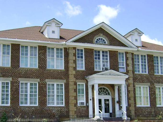 The stately brick exterior of Schoolhouse Fabrics stands as a testament to its educational past, now housing three floors of textile treasures.