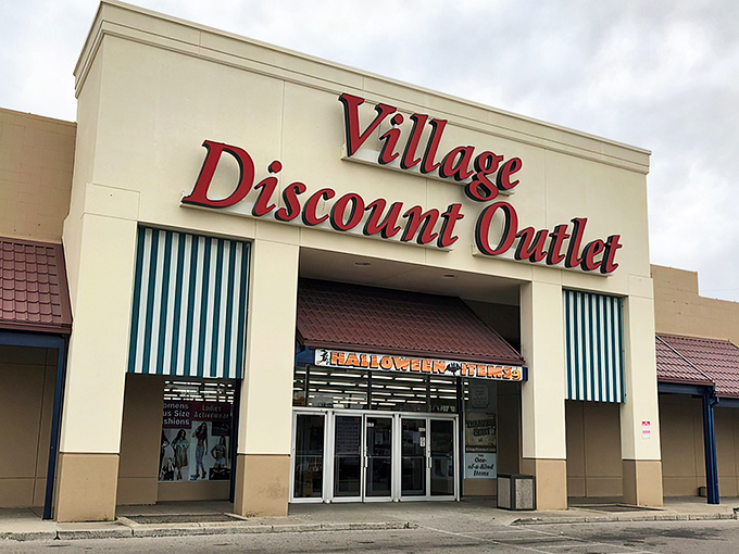 The iconic red signage of Village Discount Outlet beckons like a lighthouse for bargain hunters. Blue awnings and a spacious parking lot welcome treasure seekers of all kinds. 