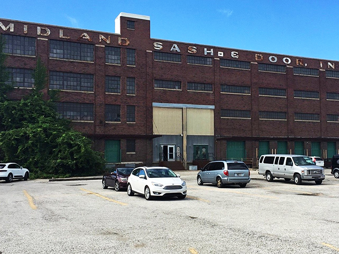 The imposing brick exterior of Midland Arts & Antiques Market still proudly displays its "SASH & DOOR" industrial heritage, promising treasures within those weathered walls.