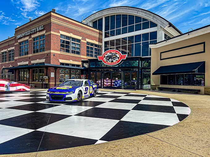 The checkered plaza welcomes speed enthusiasts like a starting line, with the sleek museum fa&ccedil;ade promising treasures that would make any gearhead's heart race faster than a qualifying lap.