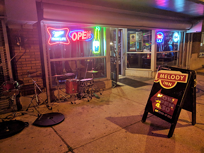 The neon glow of Melody Inn beckons like a lighthouse for music lovers, with its unassuming exterior hiding decades of Indianapolis rock history.