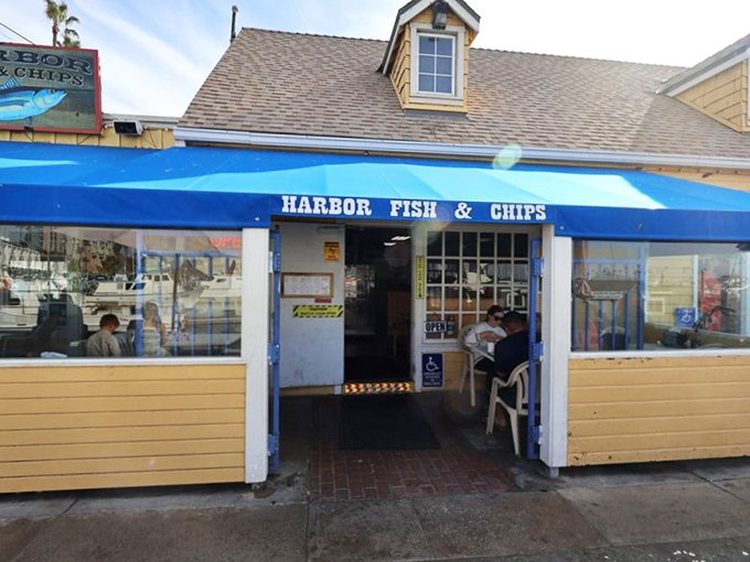The bright blue awning of Harbor Fish & Chips stands as a beacon for seafood lovers, promising simple pleasures done right in Oceanside Harbor.