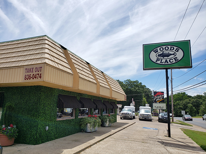 The unassuming exterior of Woods Place, with its distinctive green trim and simple sign, stands as Camden's culinary beacon for catfish aficionados.