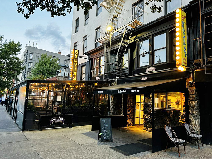 The classic New York storefront beckons with its iconic yellow sign &ndash; Sylvia's standing proud on Malcolm X Boulevard like a culinary lighthouse in Harlem. 