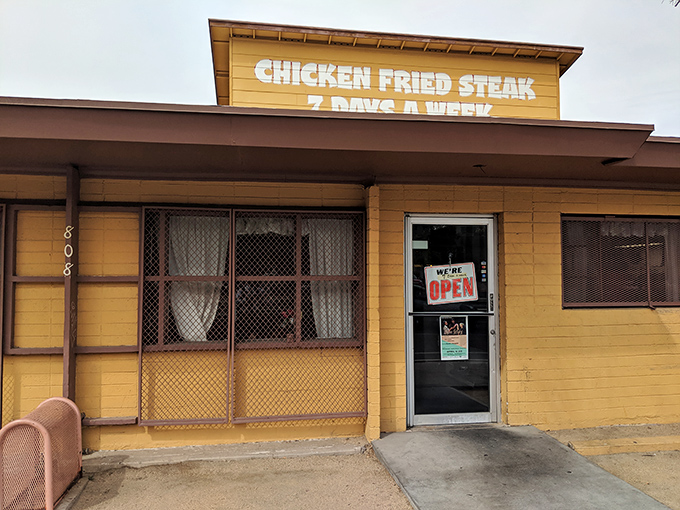 The unassuming yellow exterior of Mrs. White's Golden Rule Cafe stands like a beacon of culinary promise, boldly advertising its famous chicken fried steak.