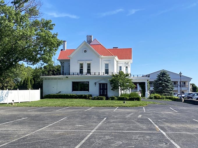 The white colonial mansion with its distinctive red roof stands as a beacon of Southern hospitality, promising culinary treasures within its historic walls.