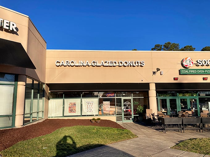 The unassuming storefront holds sweet treasures within. Like finding a $20 bill in old jeans, Carolina Glazed Donuts delivers unexpected joy. 