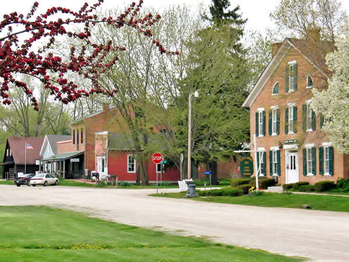 Historic storefronts framed by blooming peonies &ndash; Bentonsport's main street looks like a film set where modern life agreed to take a breather.