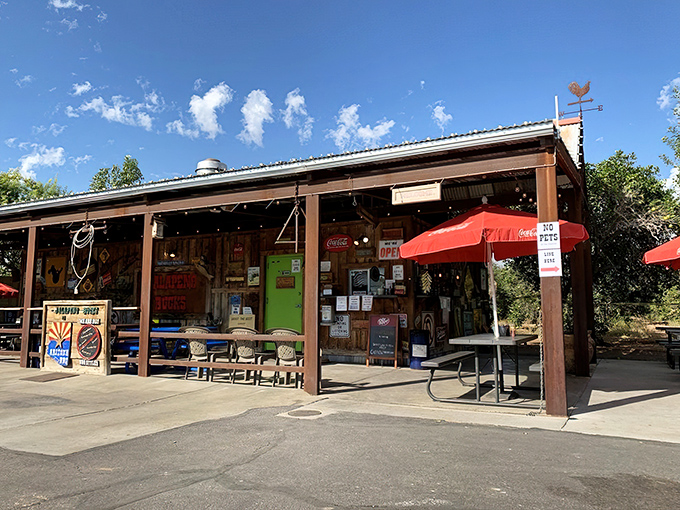 The rustic roadside charm of Jalapeño Buck's beckons hungry travelers with its weathered metal roof and promise of smoky delights ahead.