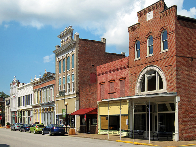 Historic brick facades line New Harmony's main street, where 19th-century architecture meets small-town charm in a perfectly preserved tableau.