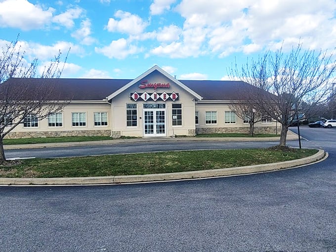 The Smyrna Diner stands proudly against a blue Delaware sky, its cream-colored exterior and distinctive sign promising comfort food salvation to hungry travelers and locals alike.