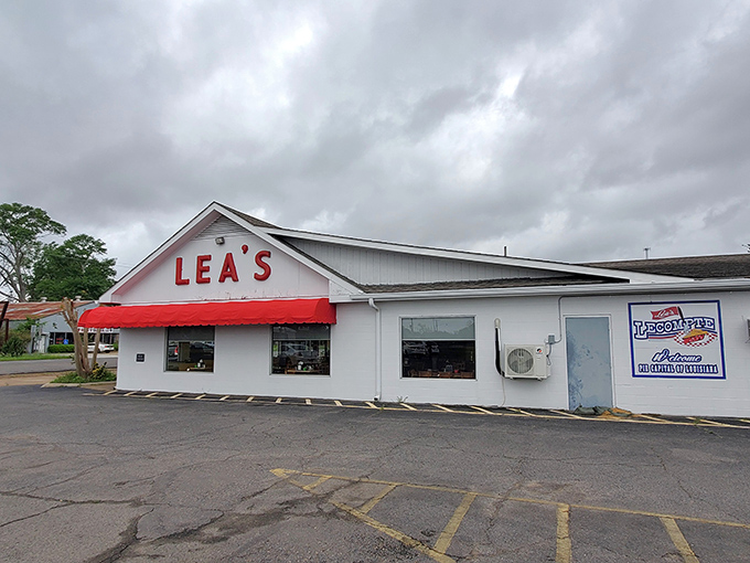Lea's iconic white exterior with its cherry-red awning stands as a beacon of hope for hungry travelers. Simple, unassuming, and promising delicious rewards inside.