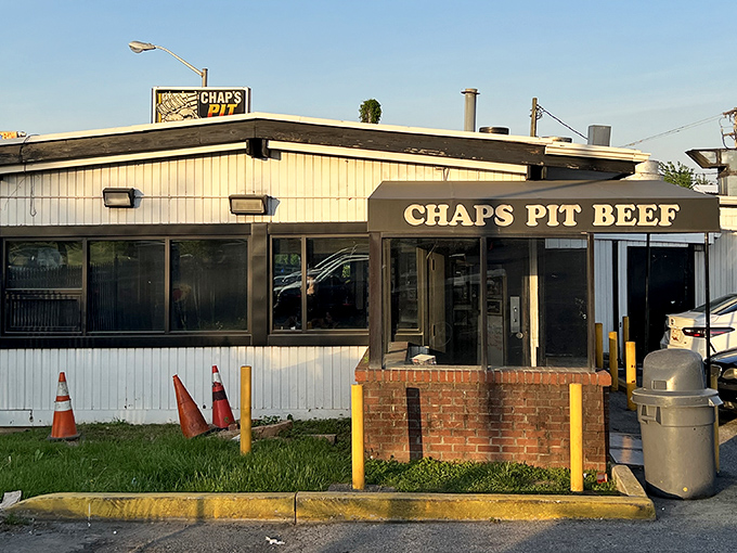 The unassuming exterior of Chaps Pit Beef stands like a beacon for barbecue pilgrims. The cartoon sign reminds you this is a destination worth driving to.