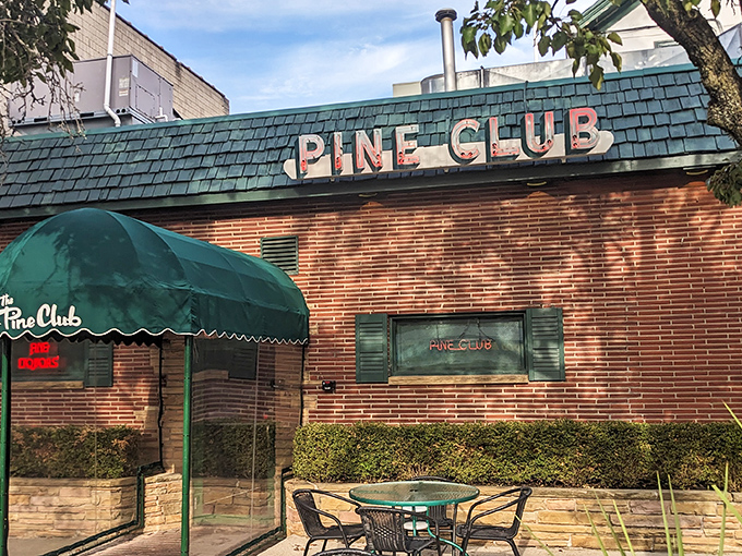 The iconic green awning and brick facade of The Pine Club stands as Dayton's temple to timeless steakhouse tradition.