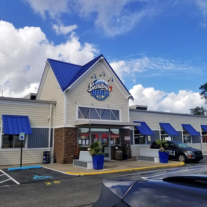 Bethany Blues' inviting exterior promises barbecue salvation with its distinctive blue roof and welcoming stone entrance&mdash;a coastal Delaware landmark that beckons hungry travelers.