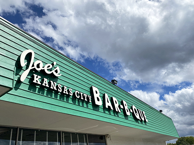 The green facade of barbecue paradise beckons like a smoky mirage. Who knew a gas station could house such legendary meaty treasures?