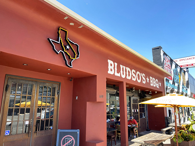 The crimson facade of Bludso's Bar & Que stands like a beacon of barbecue hope on La Brea, promising smoky salvation to meat lovers everywhere.