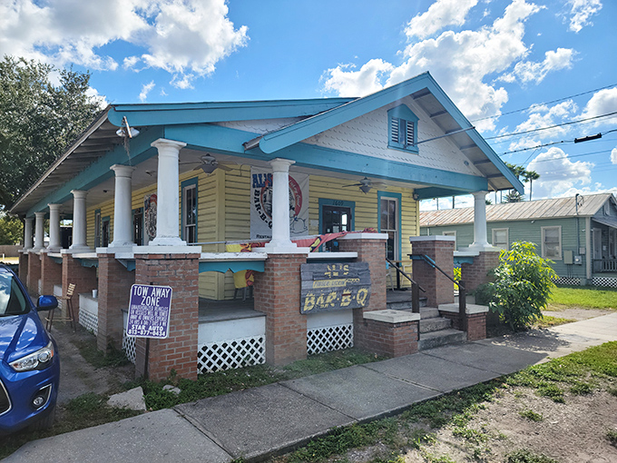 The yellow bungalow with turquoise trim stands like a barbecue beacon in Tampa, promising smoky treasures within its humble walls.