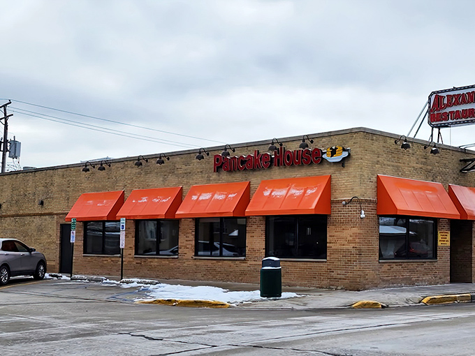 The iconic red awning of Alexander's stands out like a breakfast lighthouse, beckoning hungry travelers with its promise of pancake perfection.
