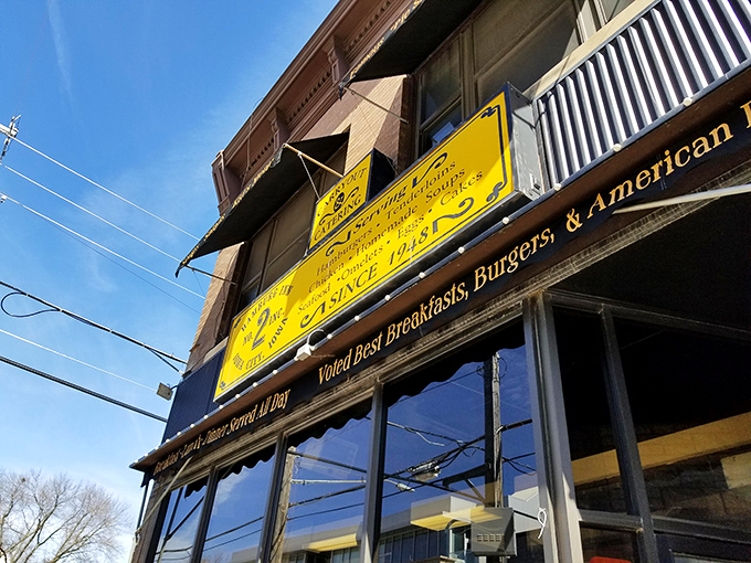 The iconic yellow sign of Hamburg Inn No. 2 stands as Iowa City's culinary lighthouse, beckoning hungry travelers with promises of "HAMBURGERS PIESHAKES" since 1948.