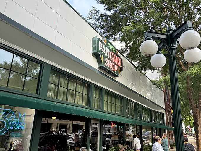 The iconic green sign beckons like a breakfast lighthouse on Hot Springs' Central Avenue, promising pancake perfection to early risers and brunch enthusiasts alike.