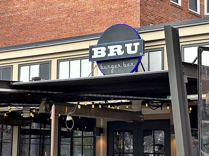 The iconic blue BRU sign beckons hungry patrons like a burger lighthouse on Mass Ave's brick-lined shores. Come for the burgers, stay for the patio vibes.