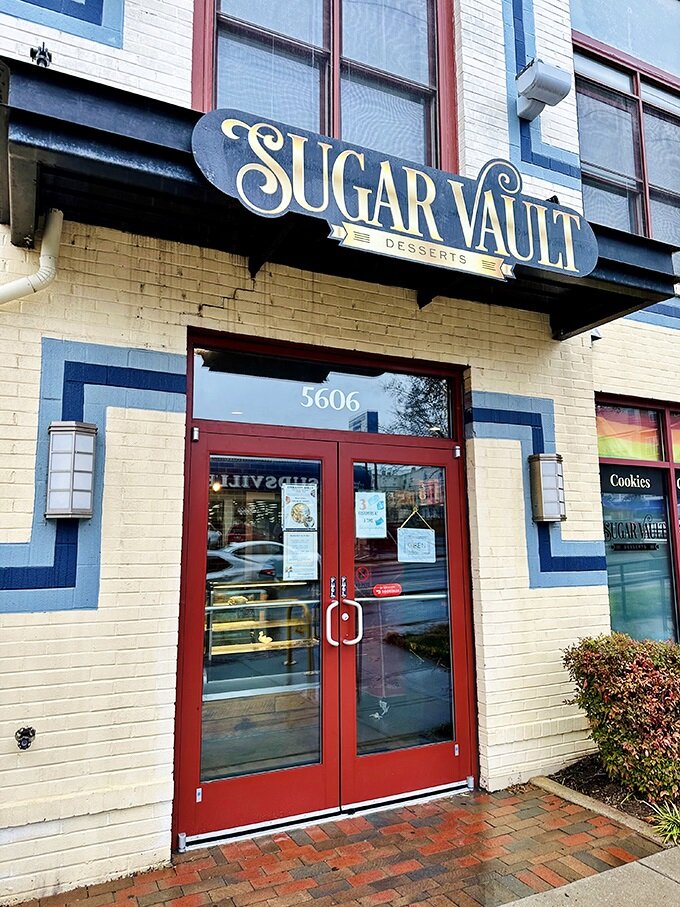 The unassuming storefront of Sugar Vault beckons like a secret treasure map to dessert paradise. Yellow brick, red doors, and sweet promises await.