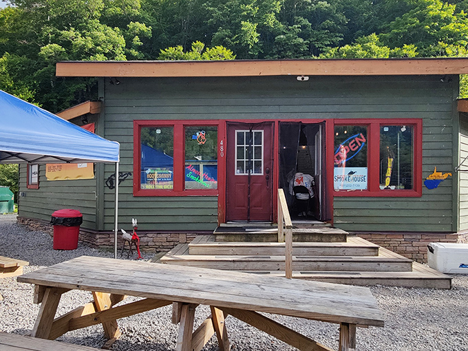 The green cabin nestled against West Virginia's lush forest backdrop isn't just a smokehouse&mdash;it's a portal to flavor country. Picnic tables await your food coma.