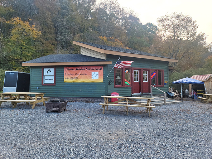 The green cabin nestled against West Virginia's lush forest backdrop isn't just a smokehouse&mdash;it's a portal to flavor country. Picnic tables await your food coma.