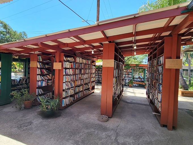 A literary wonderland unfolds beneath corrugated roofing, where signage guides bibliophiles through this open-air maze of knowledge.