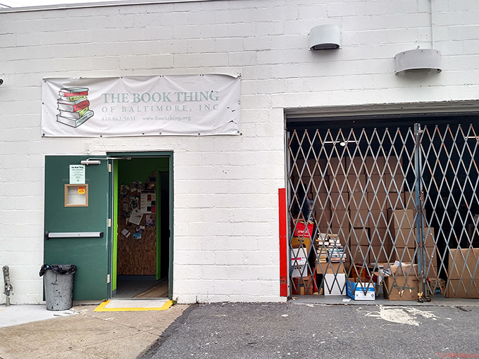 The unassuming exterior of literary heaven &ndash; a white cinder block building with a simple banner that promises bookish treasures beyond the green door.