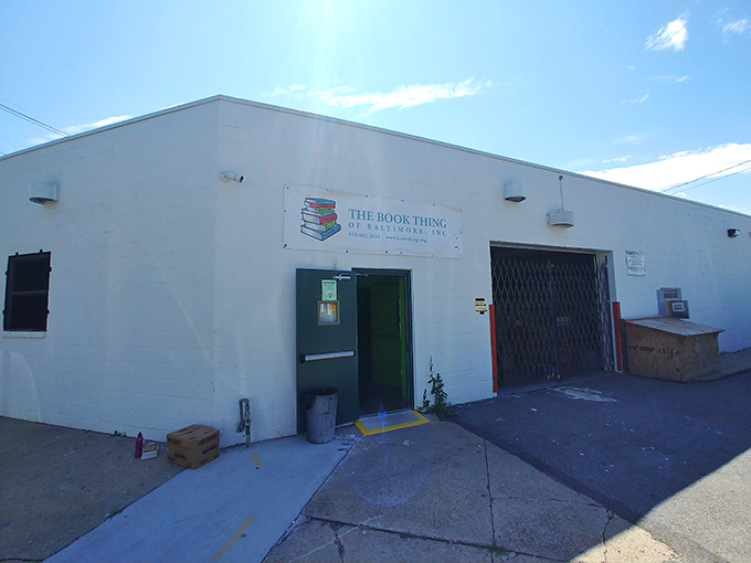 The unassuming exterior of literary heaven &ndash; a white cinder block building with a simple banner that promises bookish treasures beyond the green door.